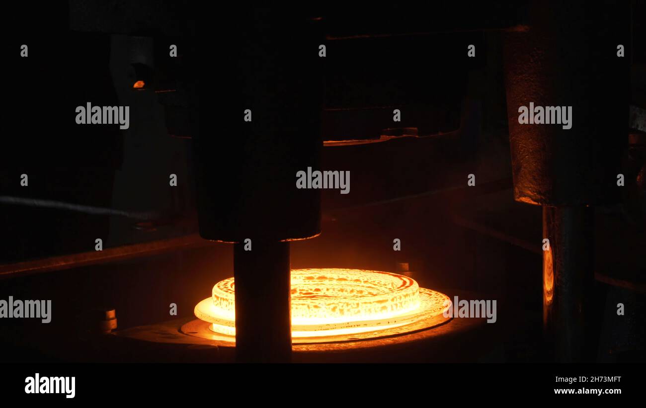 Close up of hydraulic hammer machine shapes the red hot billet at the ...