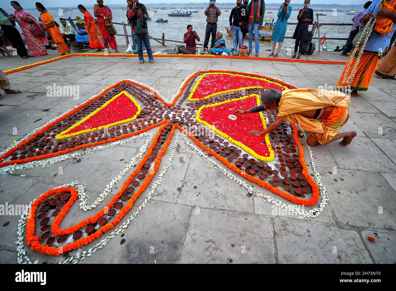 A Hindu devotee is seen making decorations on the eve of dev Deepavali ...