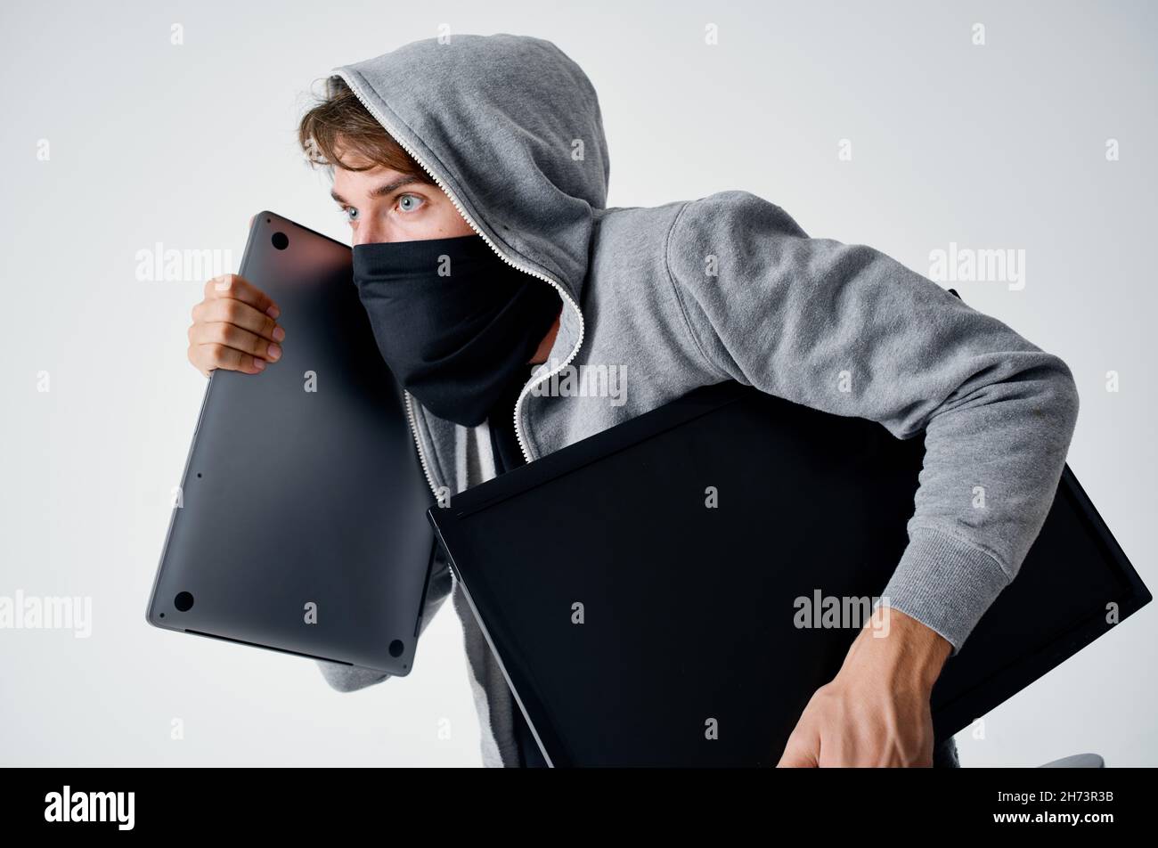 masked man hooded head hacking technology security light background Stock Photo - Alamy