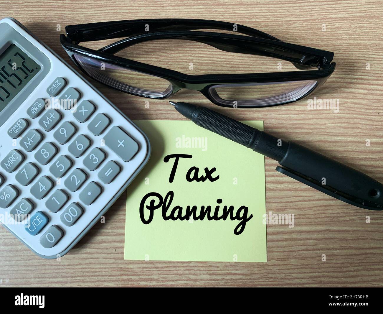Tax planning text on sticky note with calculator, glasses and pen Stock ...