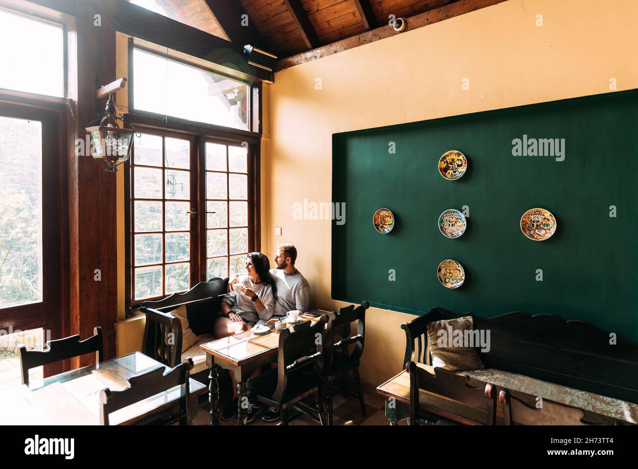 Couple in love in a cafe. Guy and girl sitting by the window in the ...