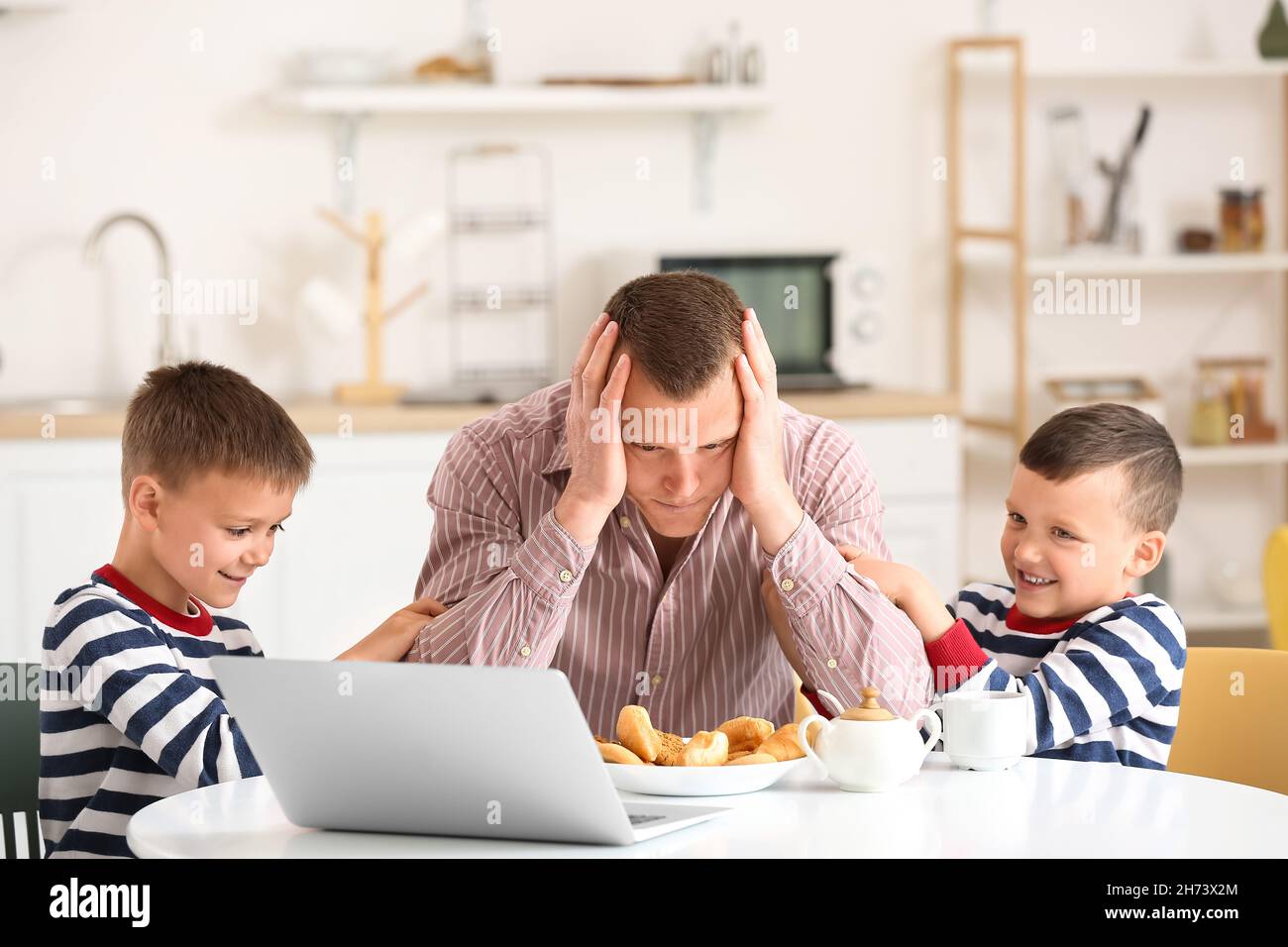 Tired father with his little children spending time together at home ...