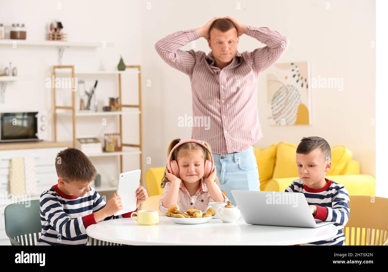 Tired father with his little children spending time together at home ...