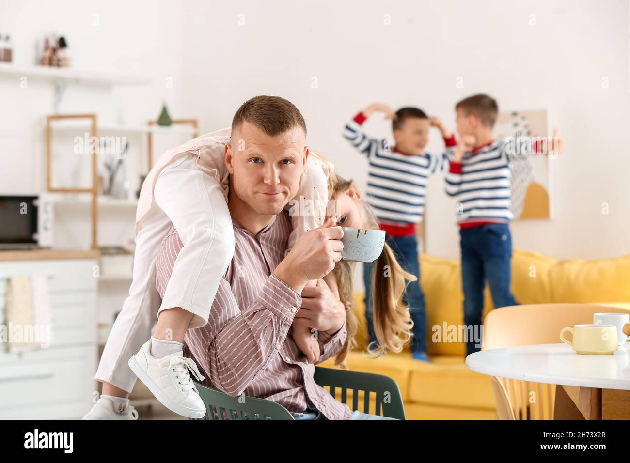 Tired father with his little children spending time together at home ...