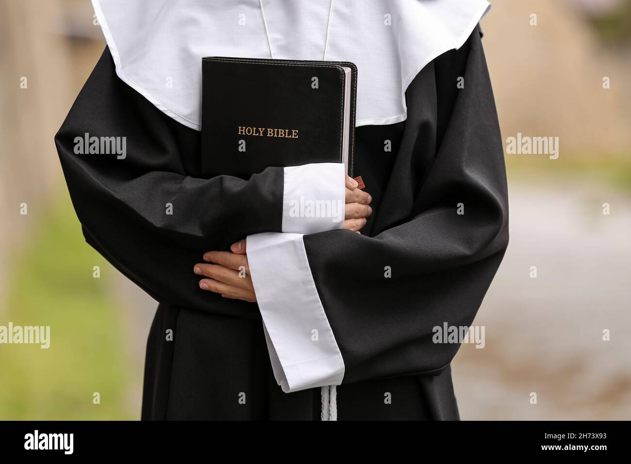 Young nun with Bible outside, closeup Stock Photo - Alamy