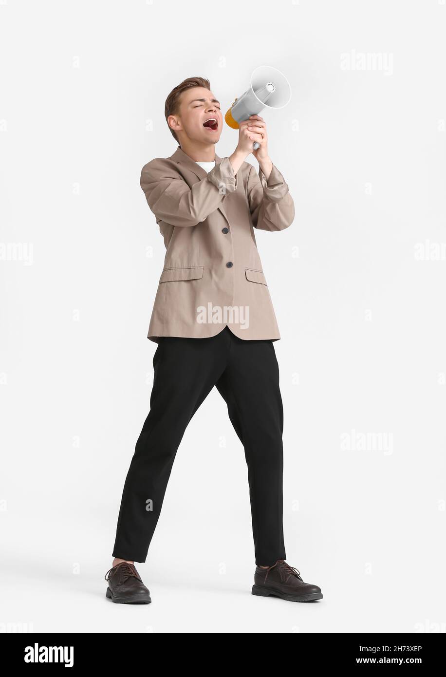 Angry teenage boy shouting into megaphone on white background Stock ...
