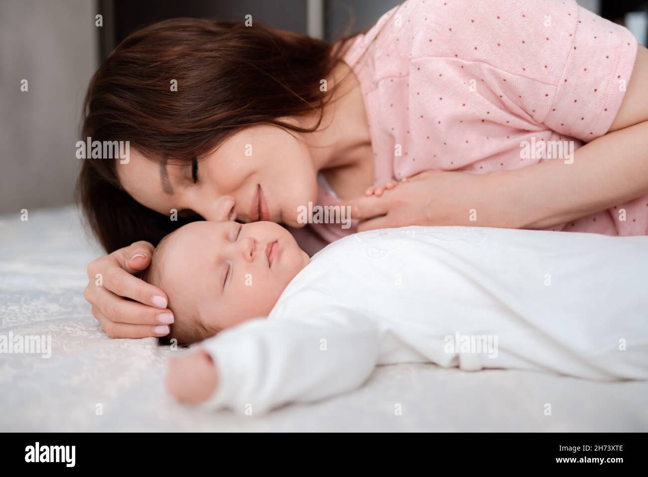 Mother takes care of her sleeping baby daughter in the bedroom Stock ...