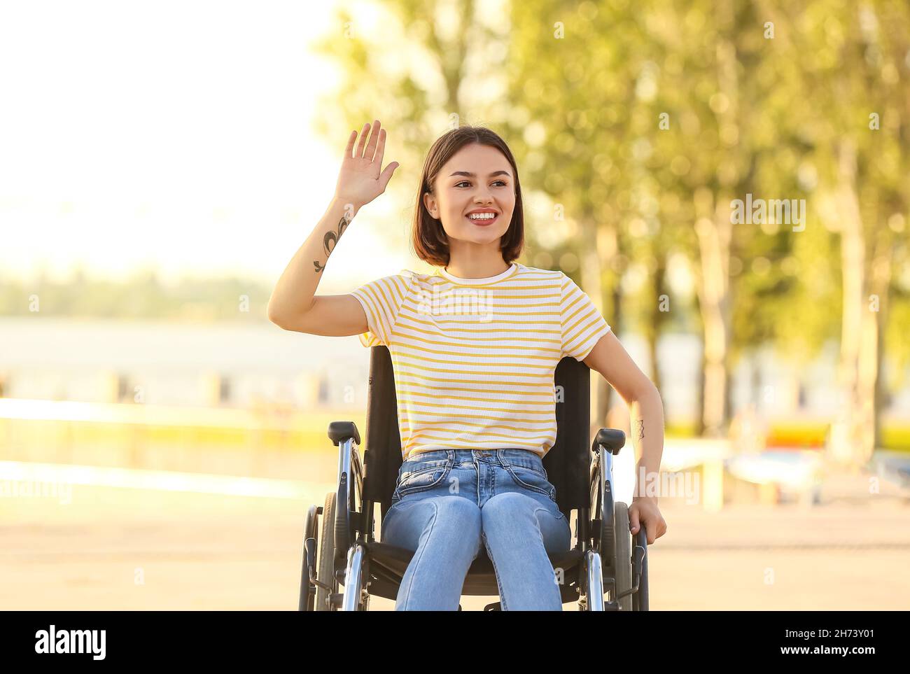 Young woman with physical disability waving hand outdoors Stock Photo ...
