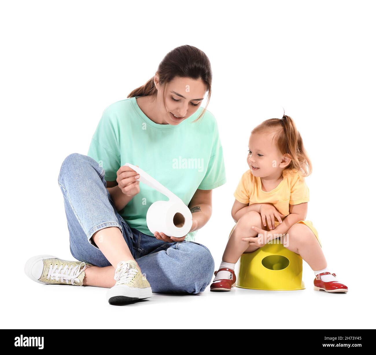 Mother potty training her little daughter on white background Stock ...