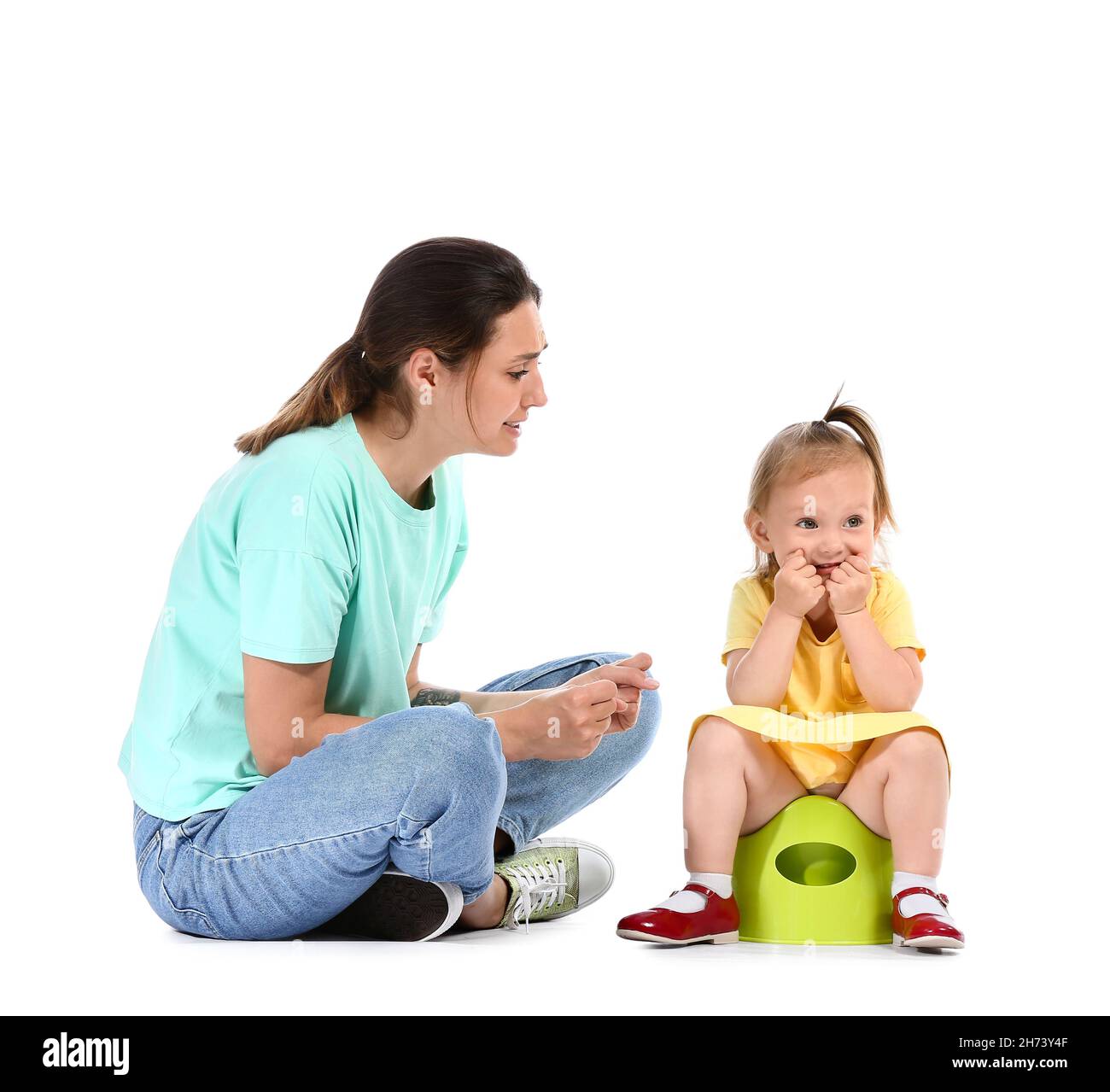 Mother potty training her little daughter on white background Stock ...