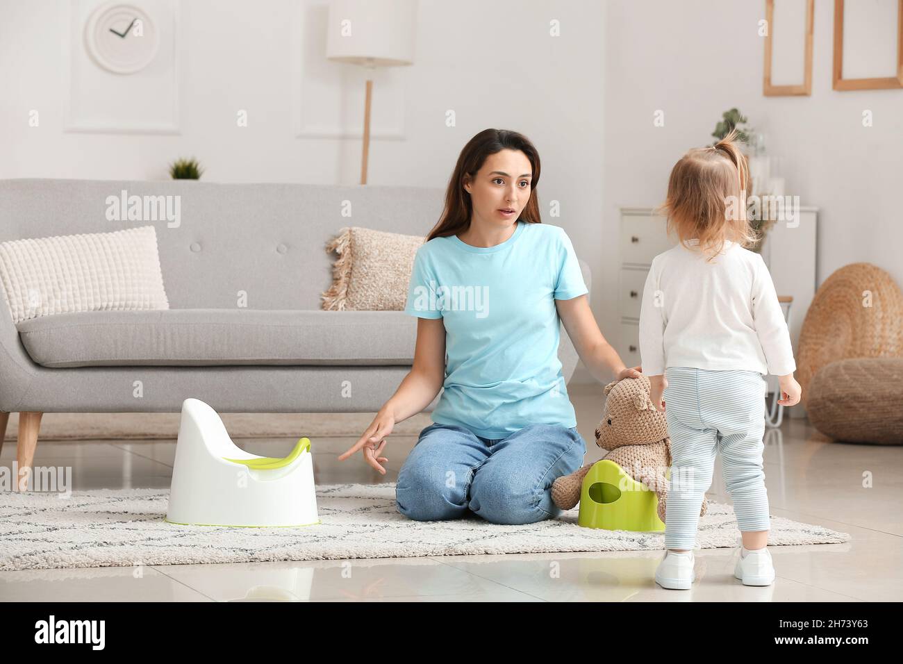 Mother potty training her little daughter at home Stock Photo - Alamy