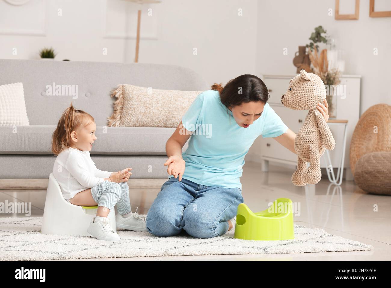 Mother potty training her little daughter at home Stock Photo - Alamy