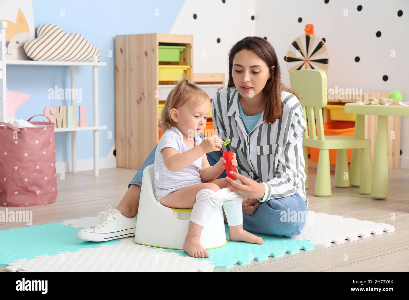 Mother potty training her little daughter at home Stock Photo - Alamy
