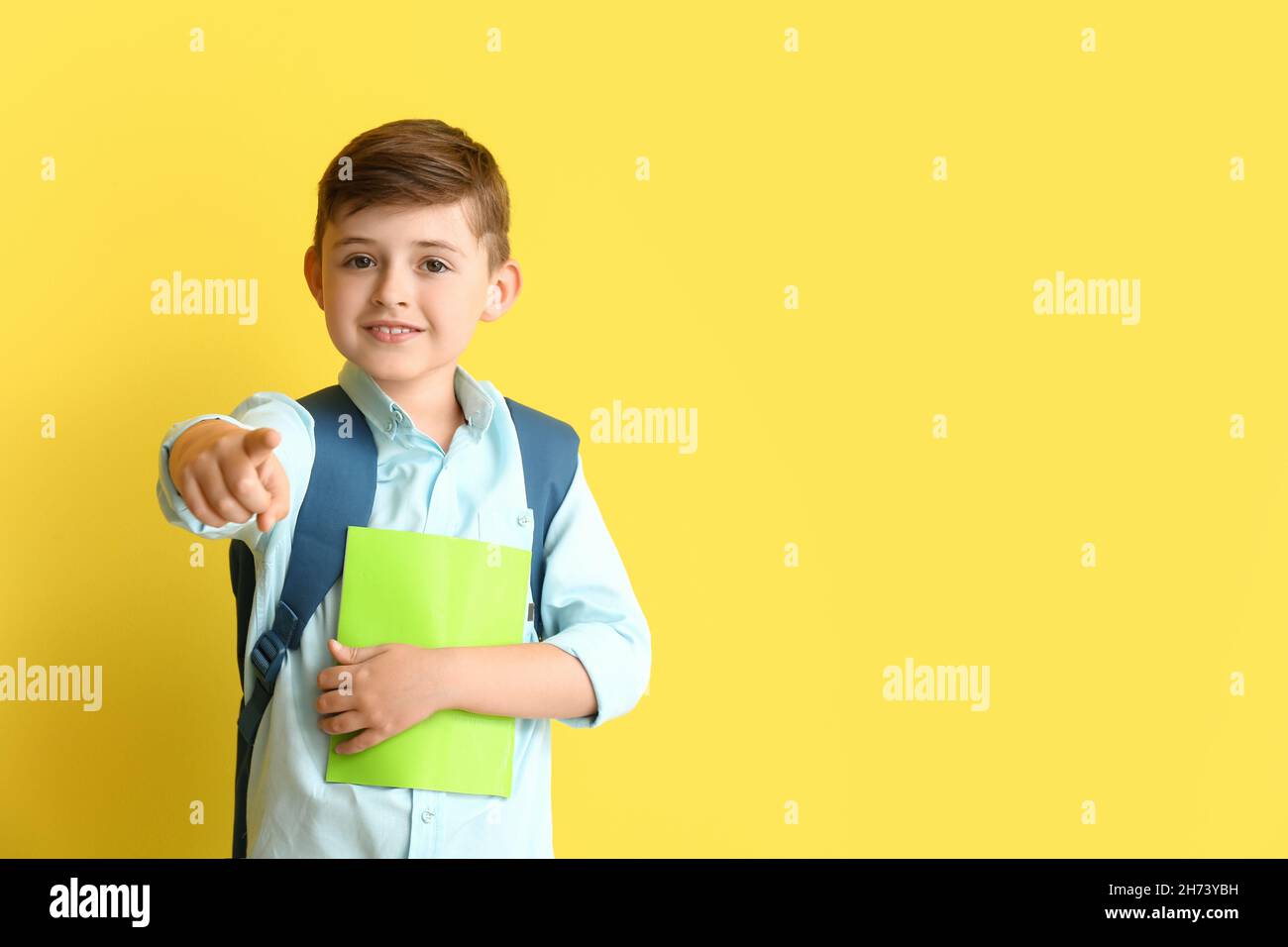 Little school boy pointing at viewer on color background Stock Photo ...