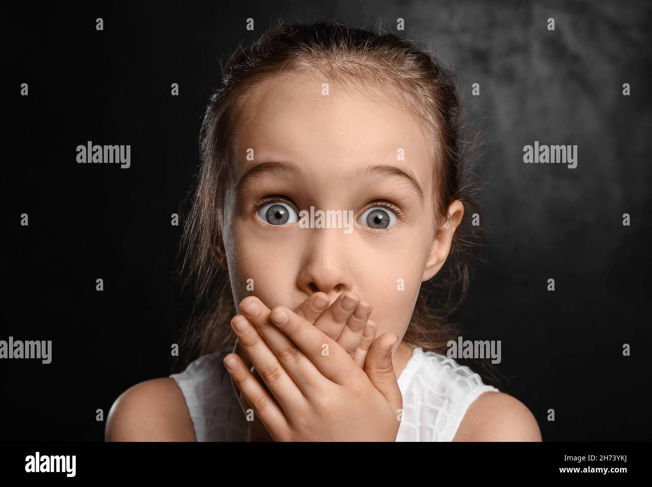 Portrait of shocked little girl on black background, closeup Stock ...