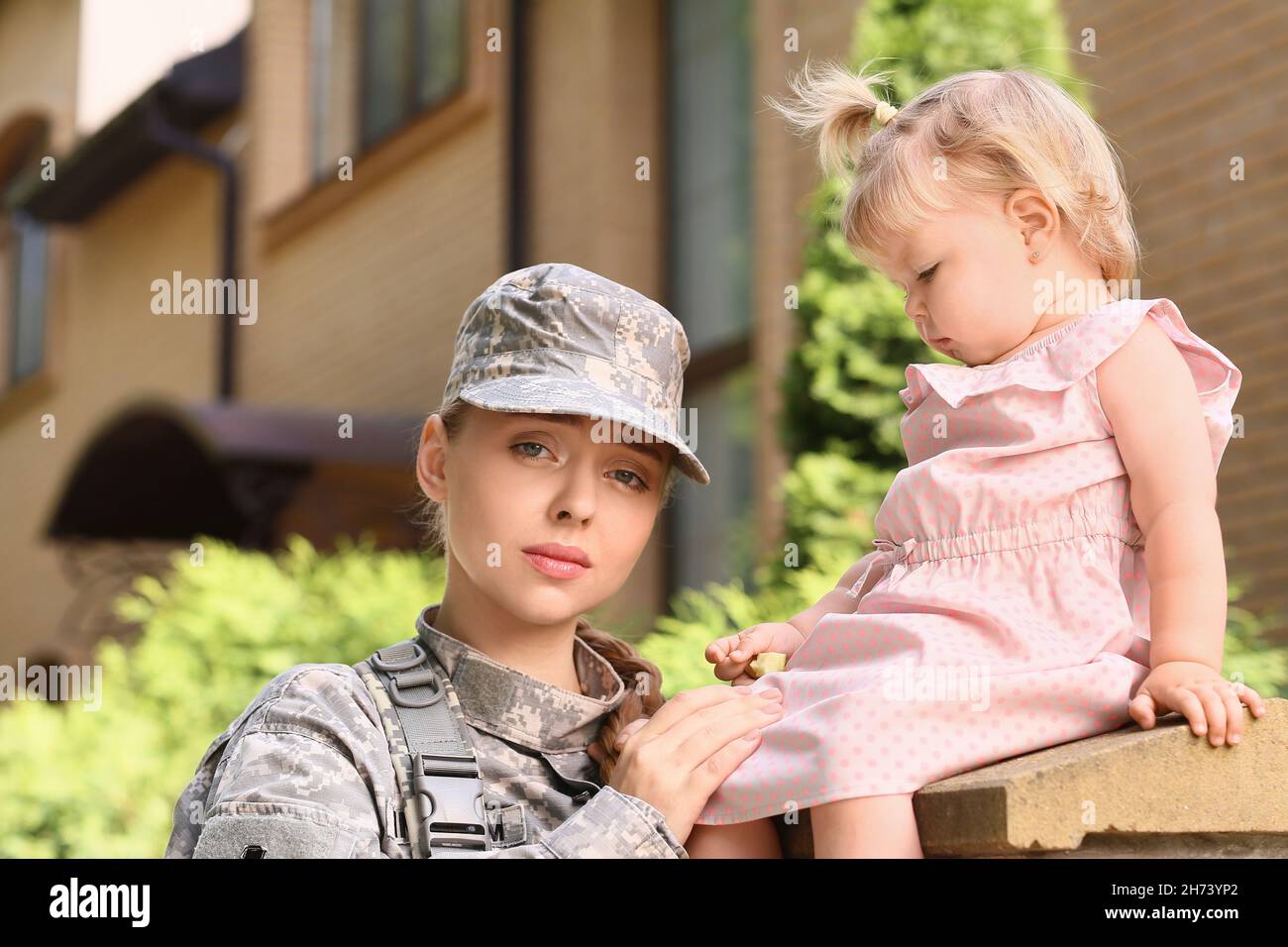 Sad female soldier with her baby girl outdoors Stock Photo - Alamy
