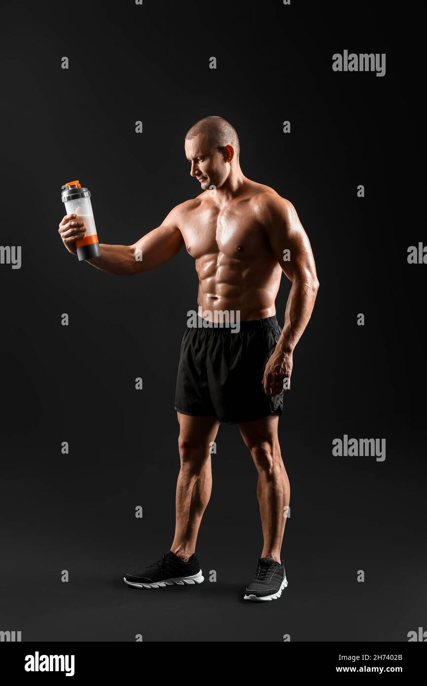 Male bodybuilder with protein shake on dark background Stock Photo - Alamy