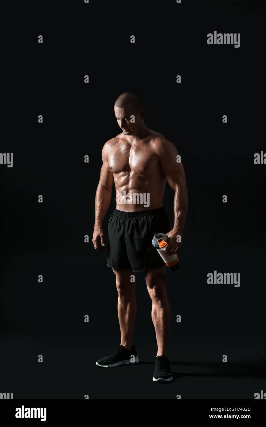 Male bodybuilder with protein shake on dark background Stock Photo - Alamy