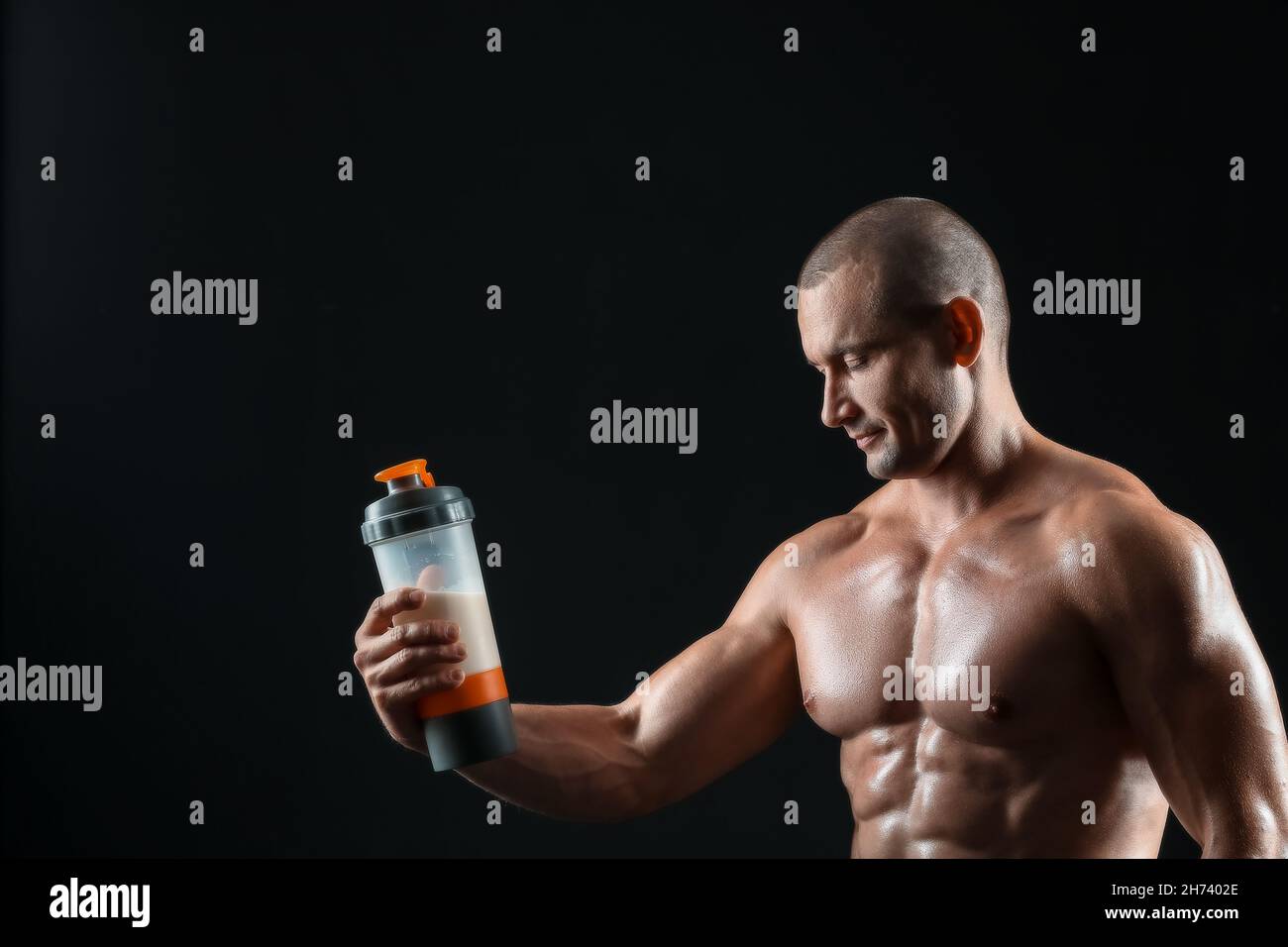 Male bodybuilder with protein shake on dark background Stock Photo - Alamy