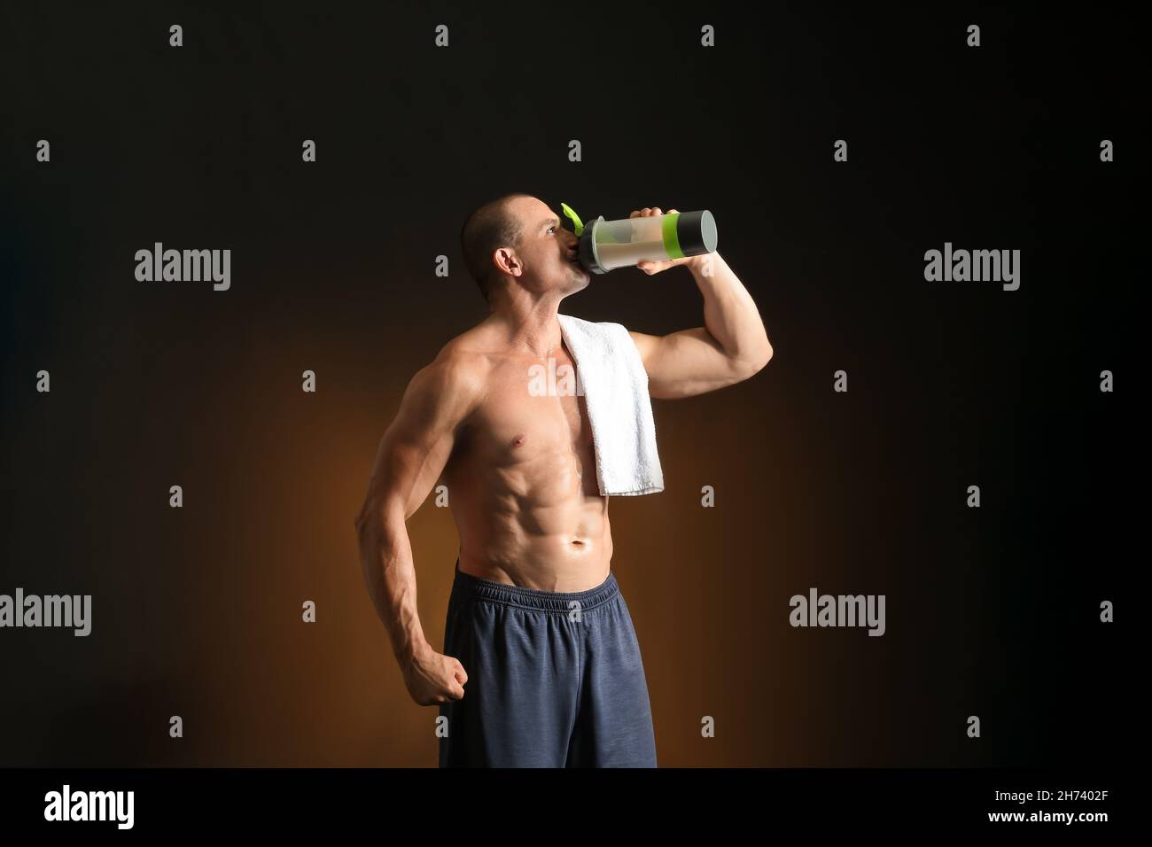 Male bodybuilder drinking protein shake on dark background Stock Photo ...