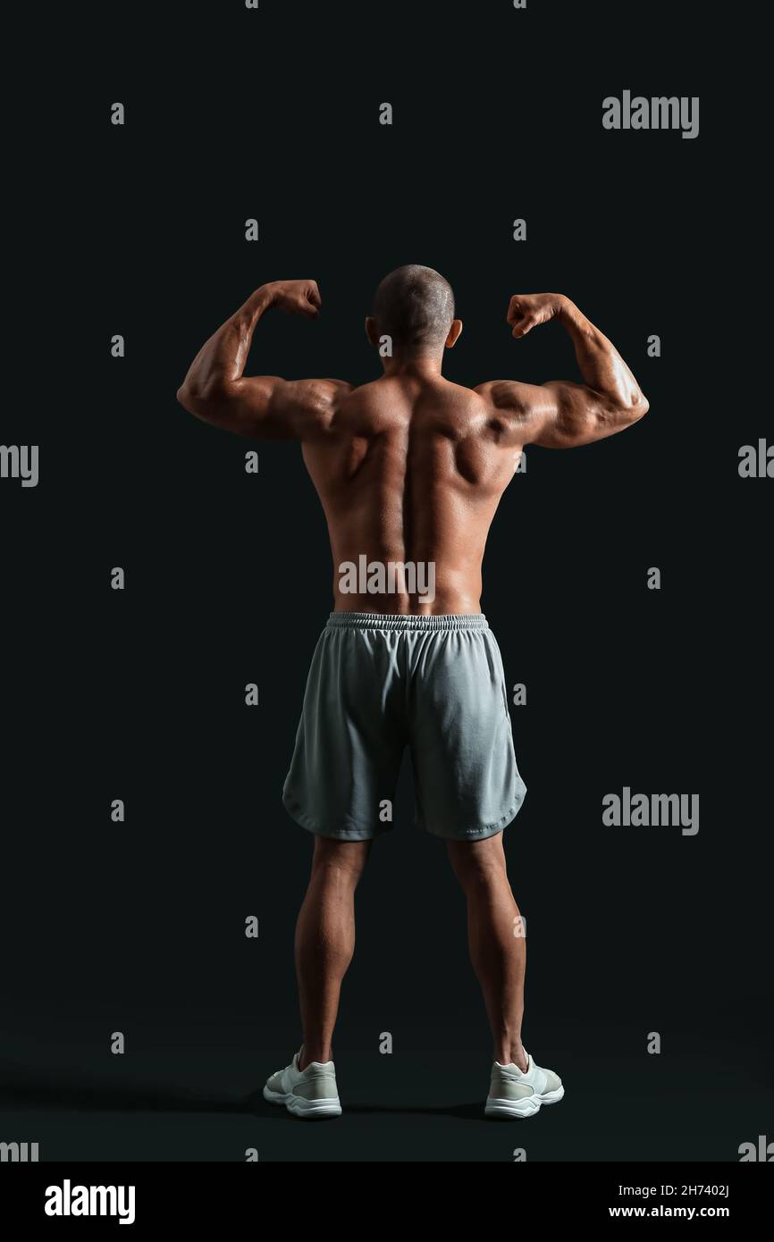 Male bodybuilder on dark background, back view Stock Photo - Alamy
