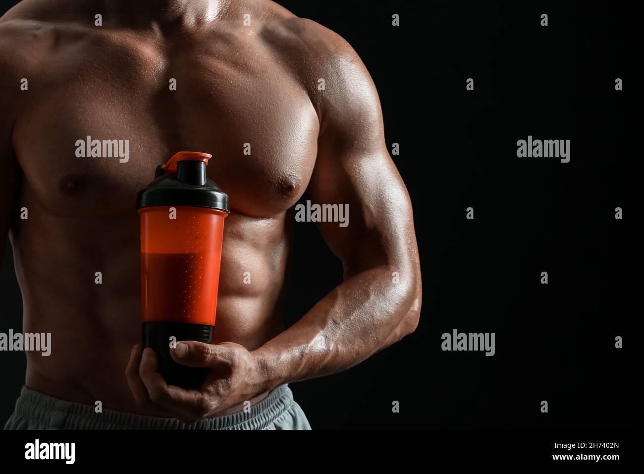 Male bodybuilder with protein shake on dark background Stock Photo - Alamy