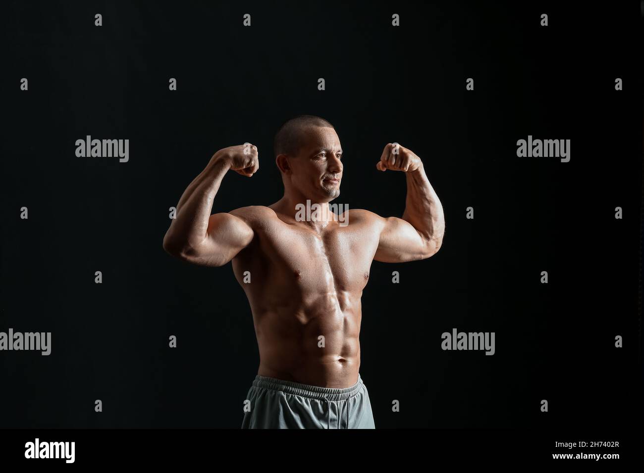 Male bodybuilder on dark background Stock Photo - Alamy