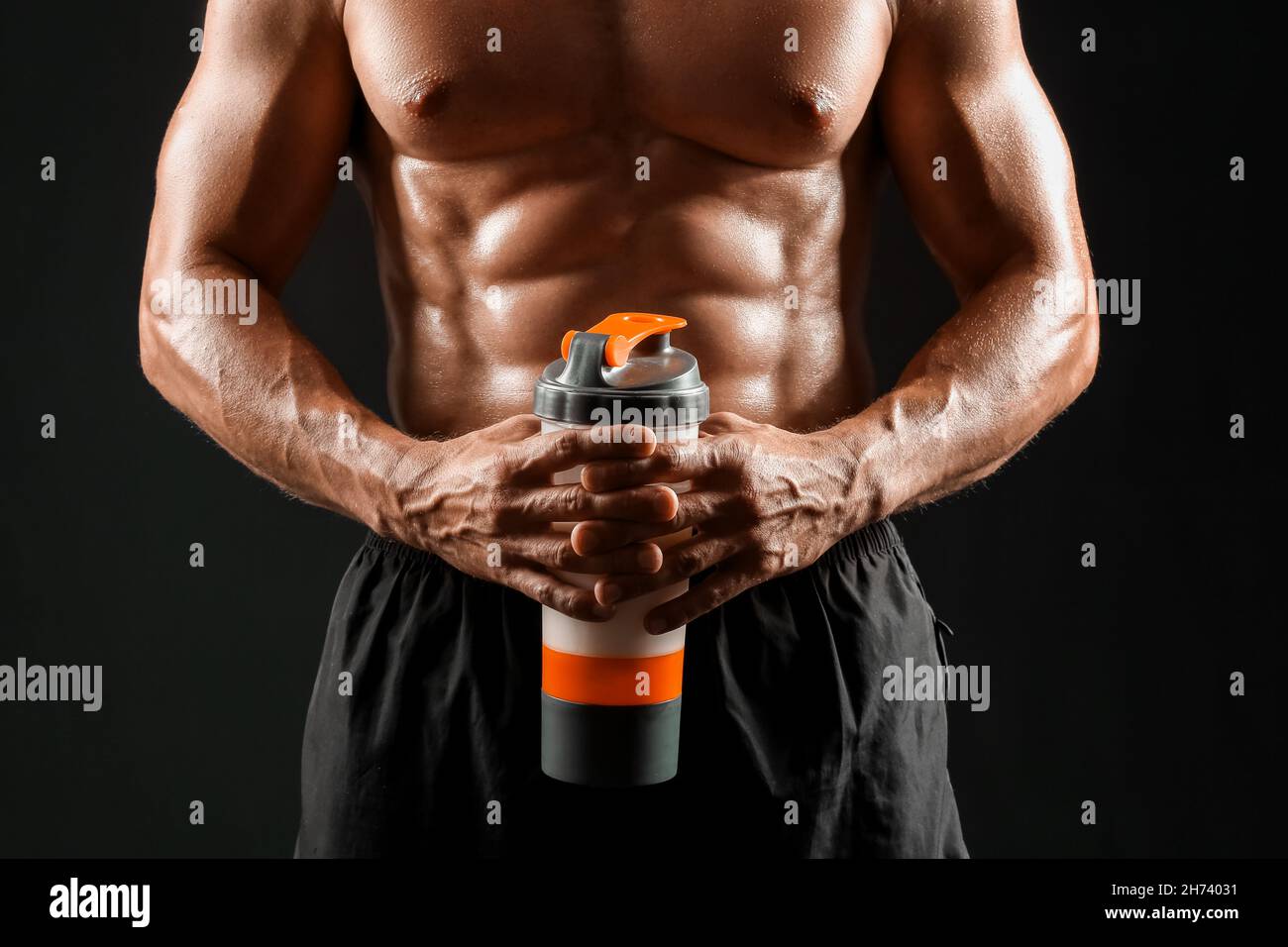 Male bodybuilder with protein shake on dark background Stock Photo - Alamy