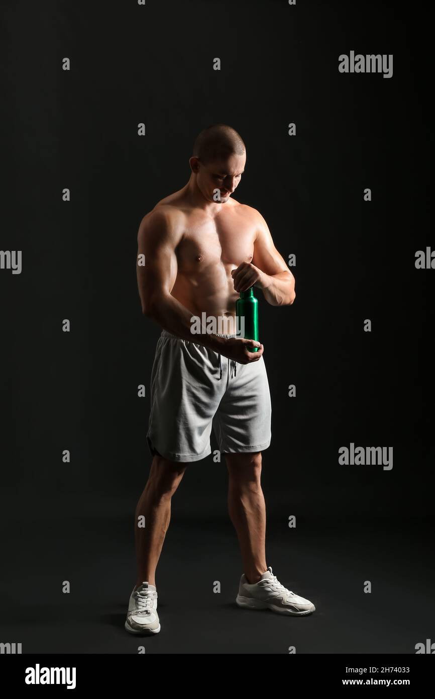 Male bodybuilder with protein shake on dark background Stock Photo - Alamy