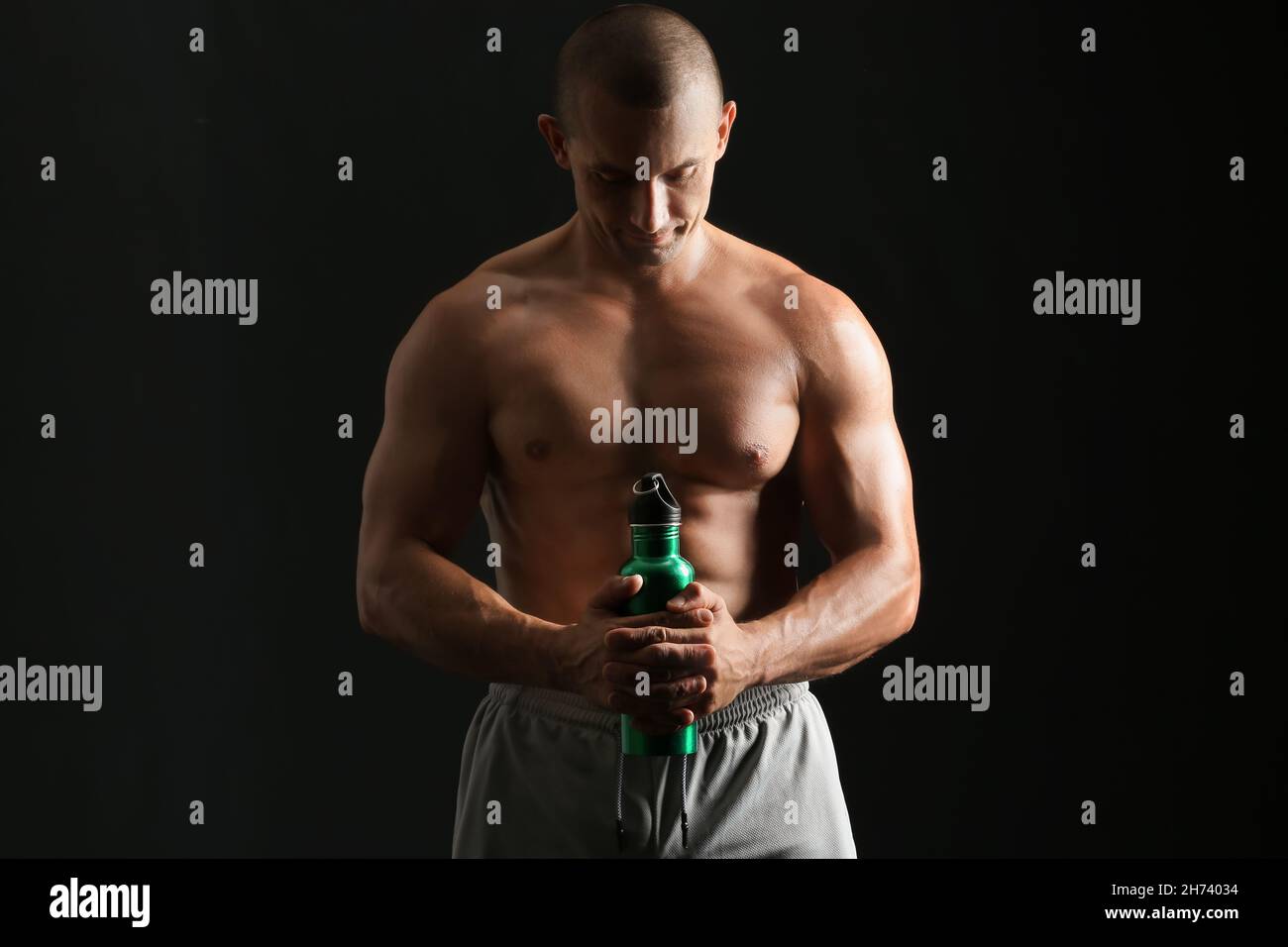 Male bodybuilder with protein shake on dark background Stock Photo - Alamy