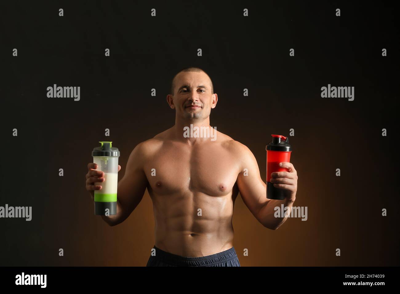 Male bodybuilder with protein shakes on dark background Stock Photo - Alamy