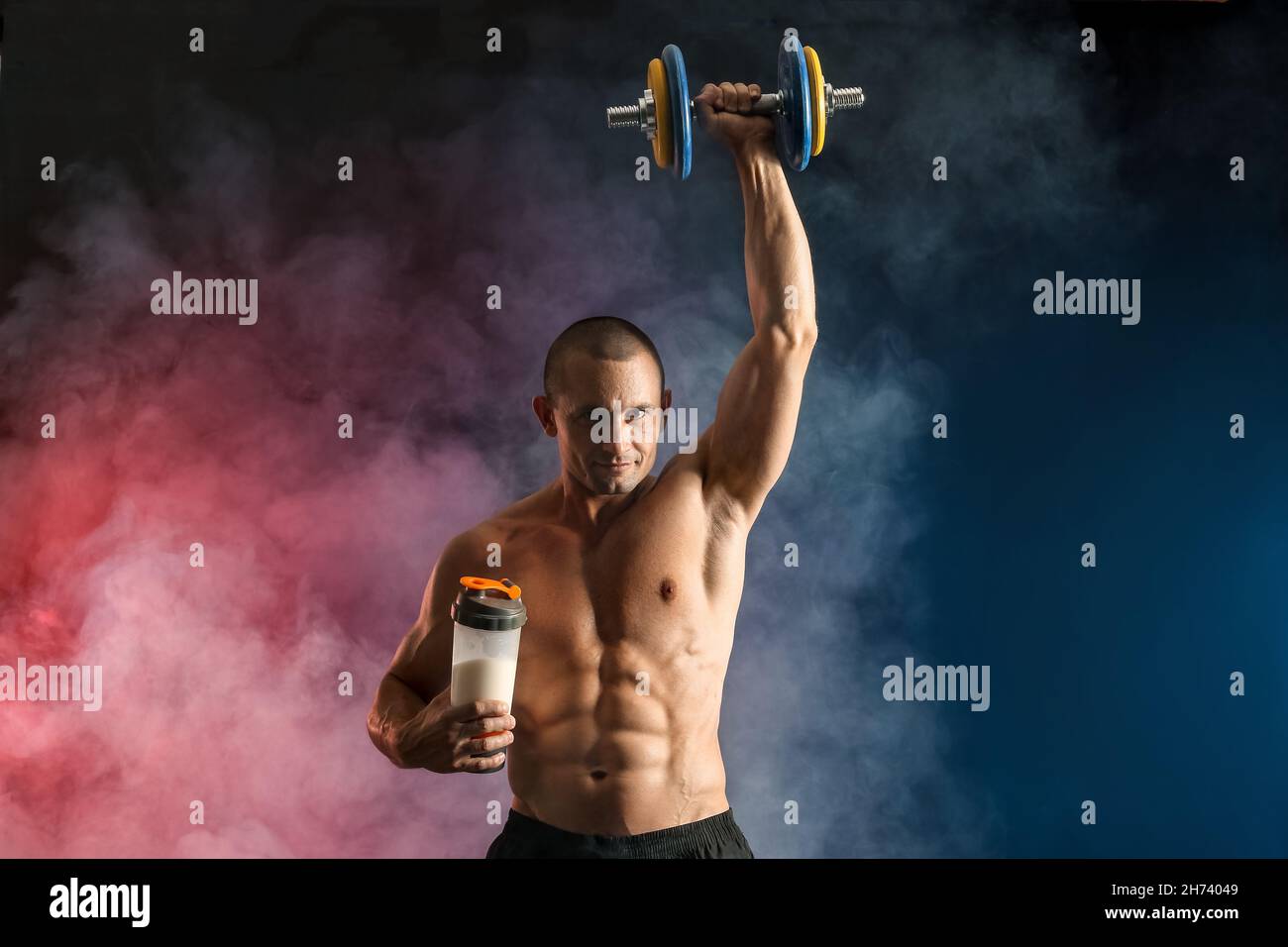 Male bodybuilder with protein shake and dumbbell on dark background ...