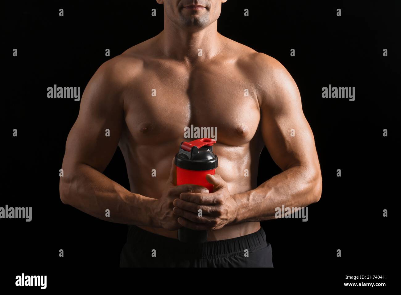 Male bodybuilder with protein shake on dark background Stock Photo - Alamy