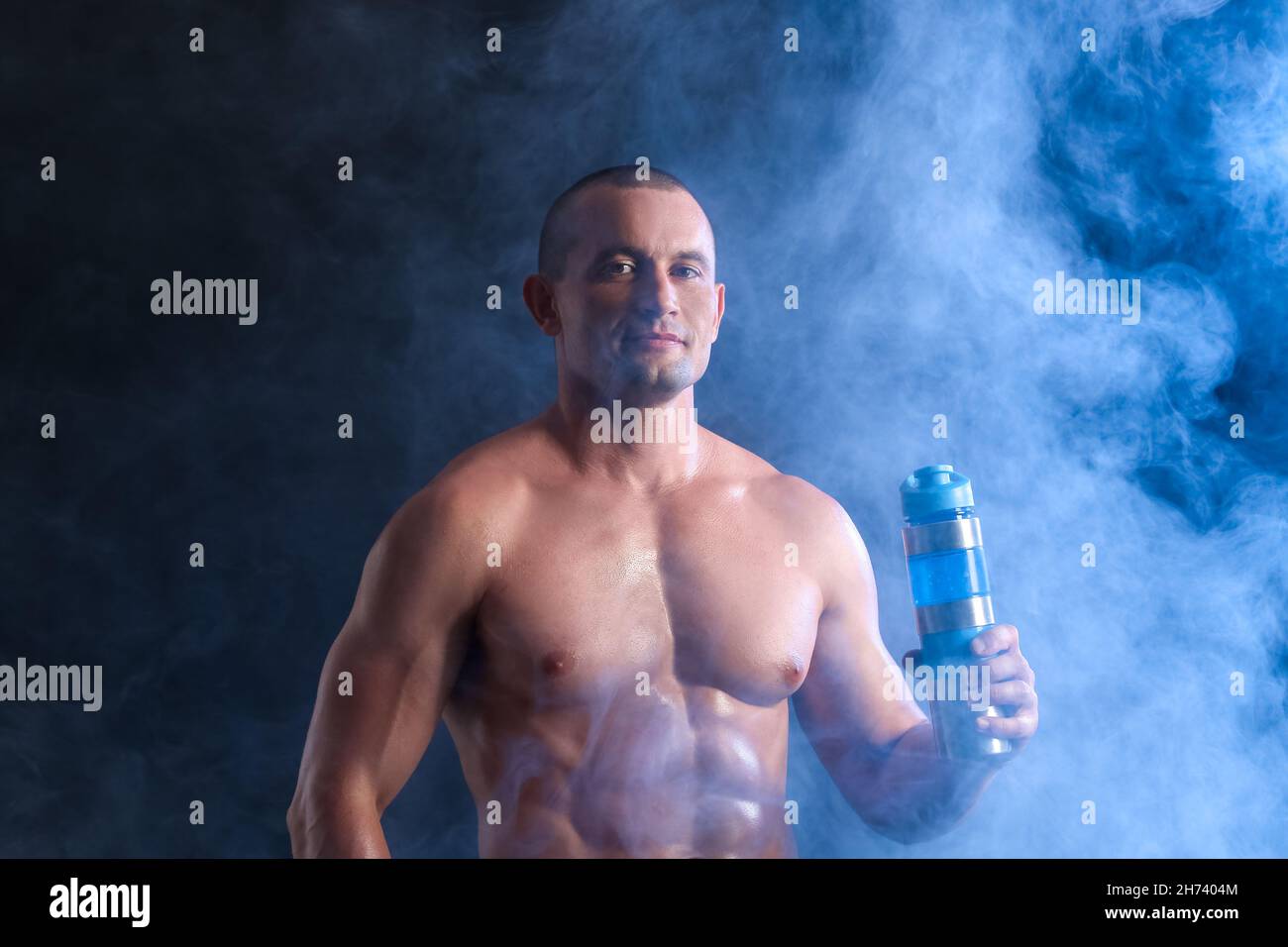 Male bodybuilder with protein shake in smoke on dark background Stock ...