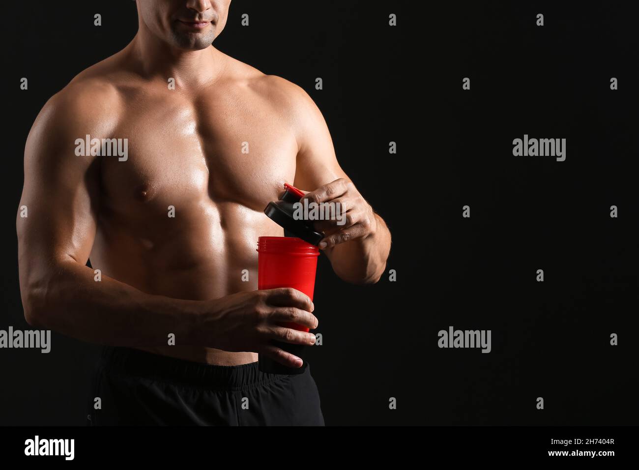 Male bodybuilder with protein shake on dark background Stock Photo - Alamy