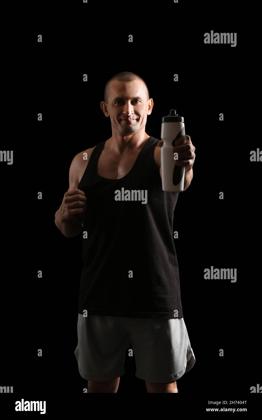 Male bodybuilder with protein shake on dark background Stock Photo - Alamy