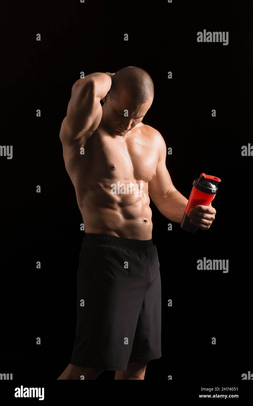 Male bodybuilder with protein shake on dark background Stock Photo - Alamy