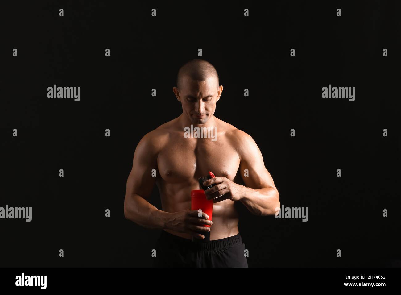 Male bodybuilder with protein shake on dark background Stock Photo - Alamy