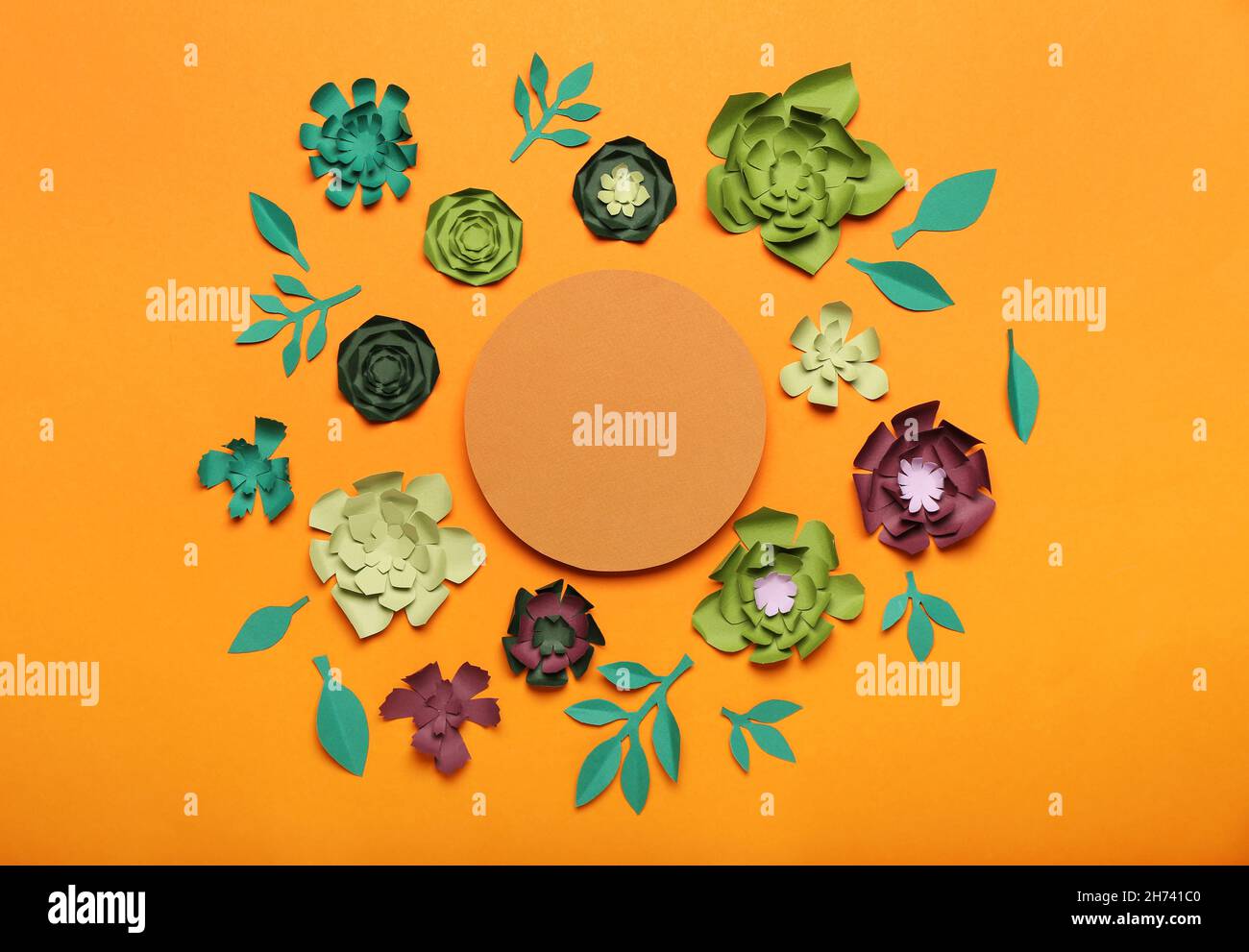 Beautiful handmade paper flowers with empty paper sheet on color ...