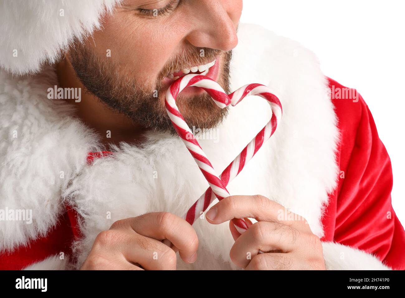 Santa Claus eating candy canes on white background Stock Photo - Alamy