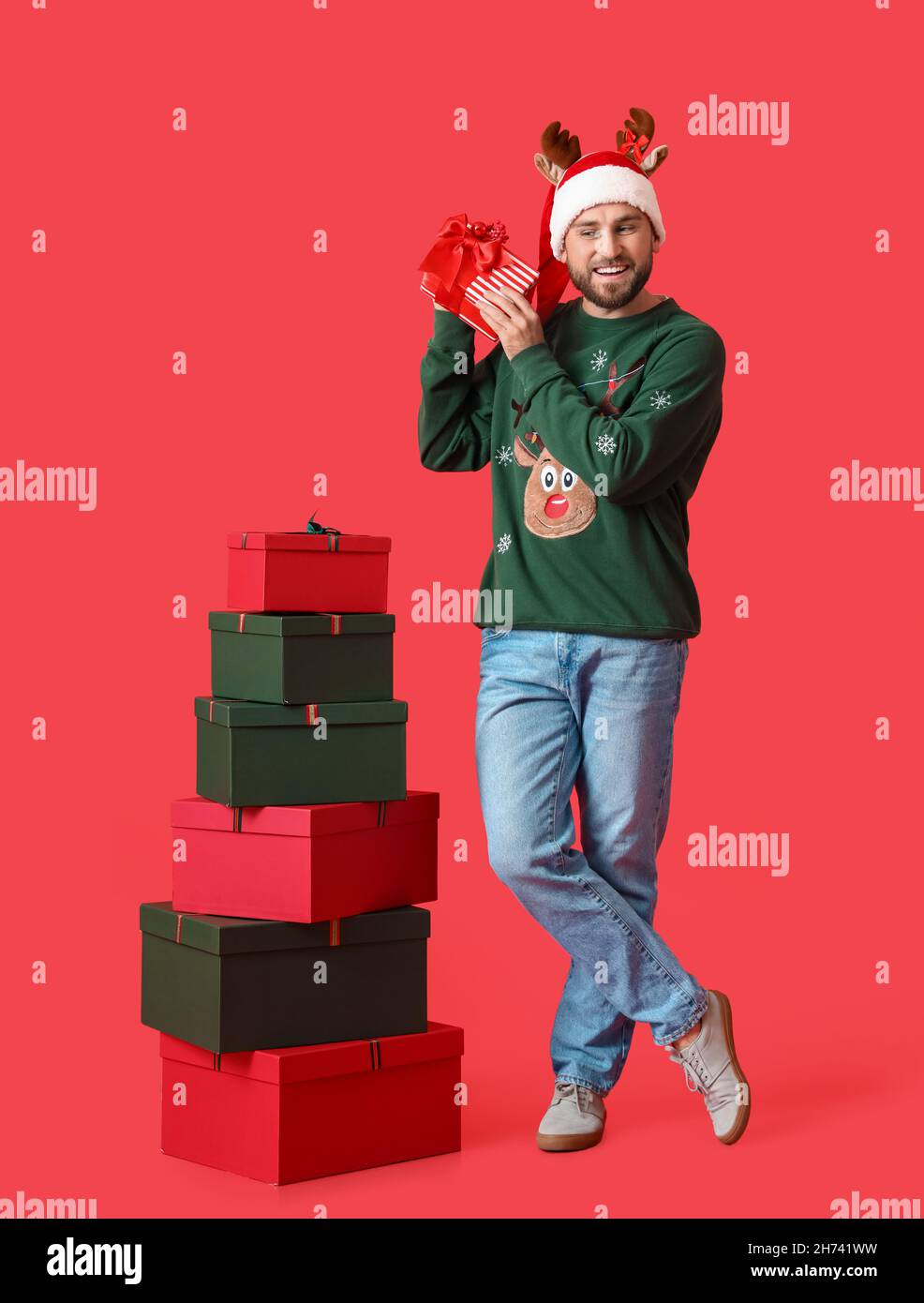 Handsome man with Christmas gifts on color background Stock Photo - Alamy