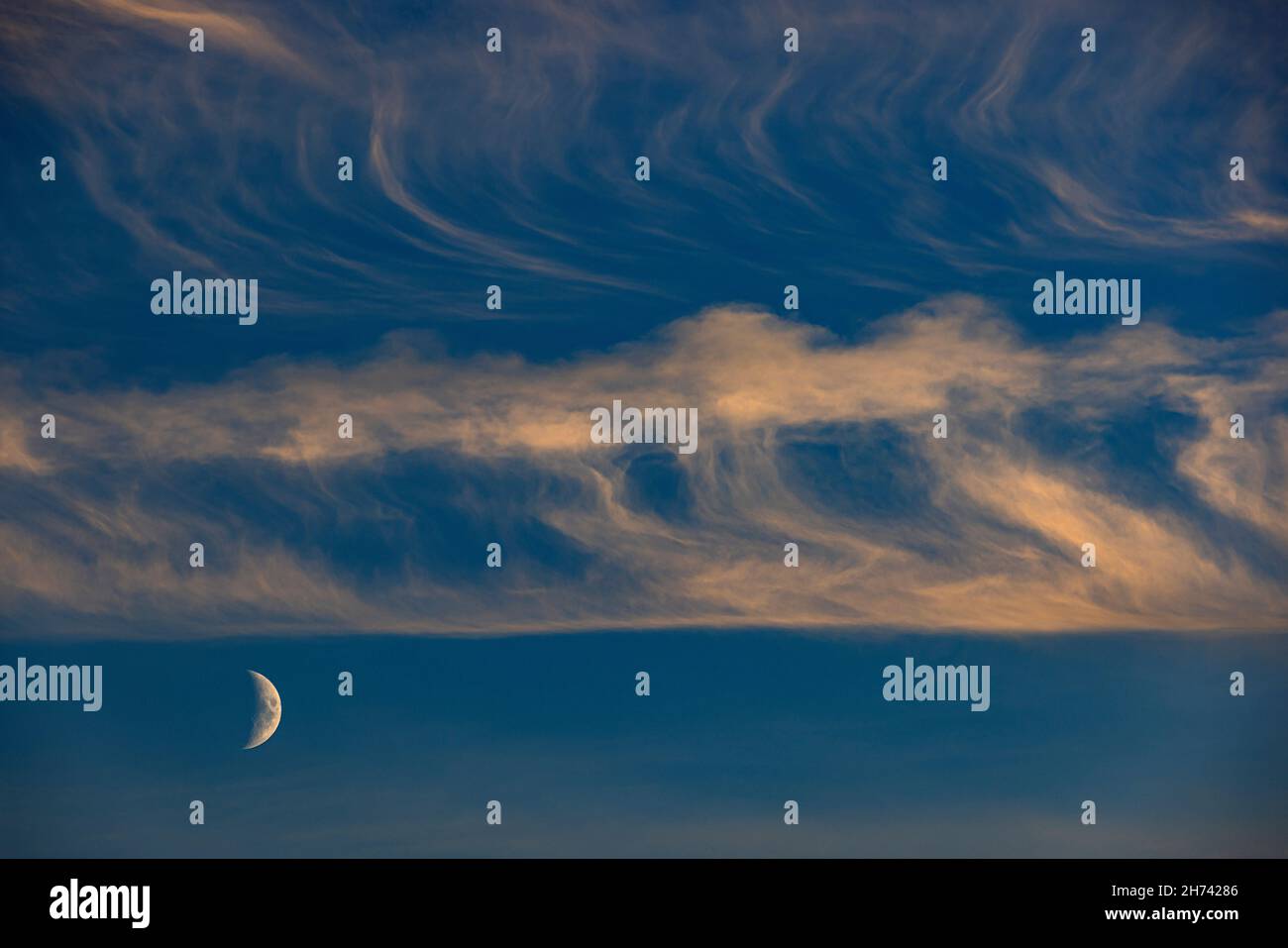 Cirrus clouds with a half moon Stock Photo - Alamy