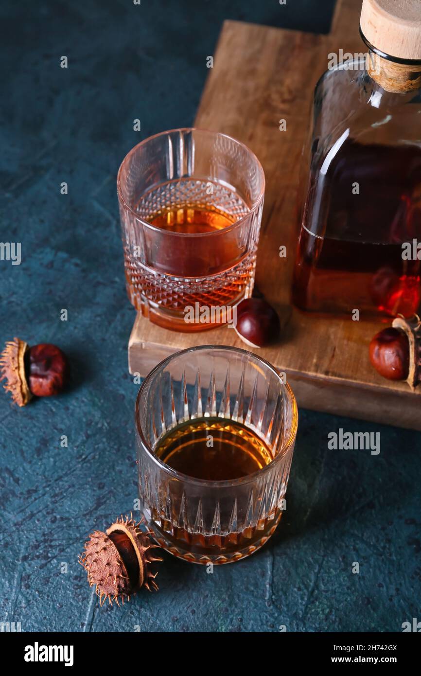Glasses of chestnut whiskey and bottle with beverage on black ...