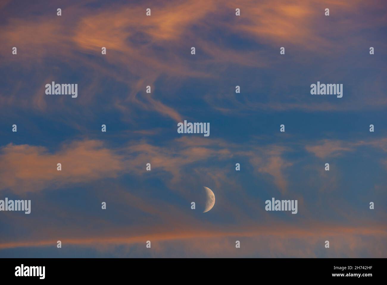 Cirrus clouds with a quarter moon Stock Photo - Alamy