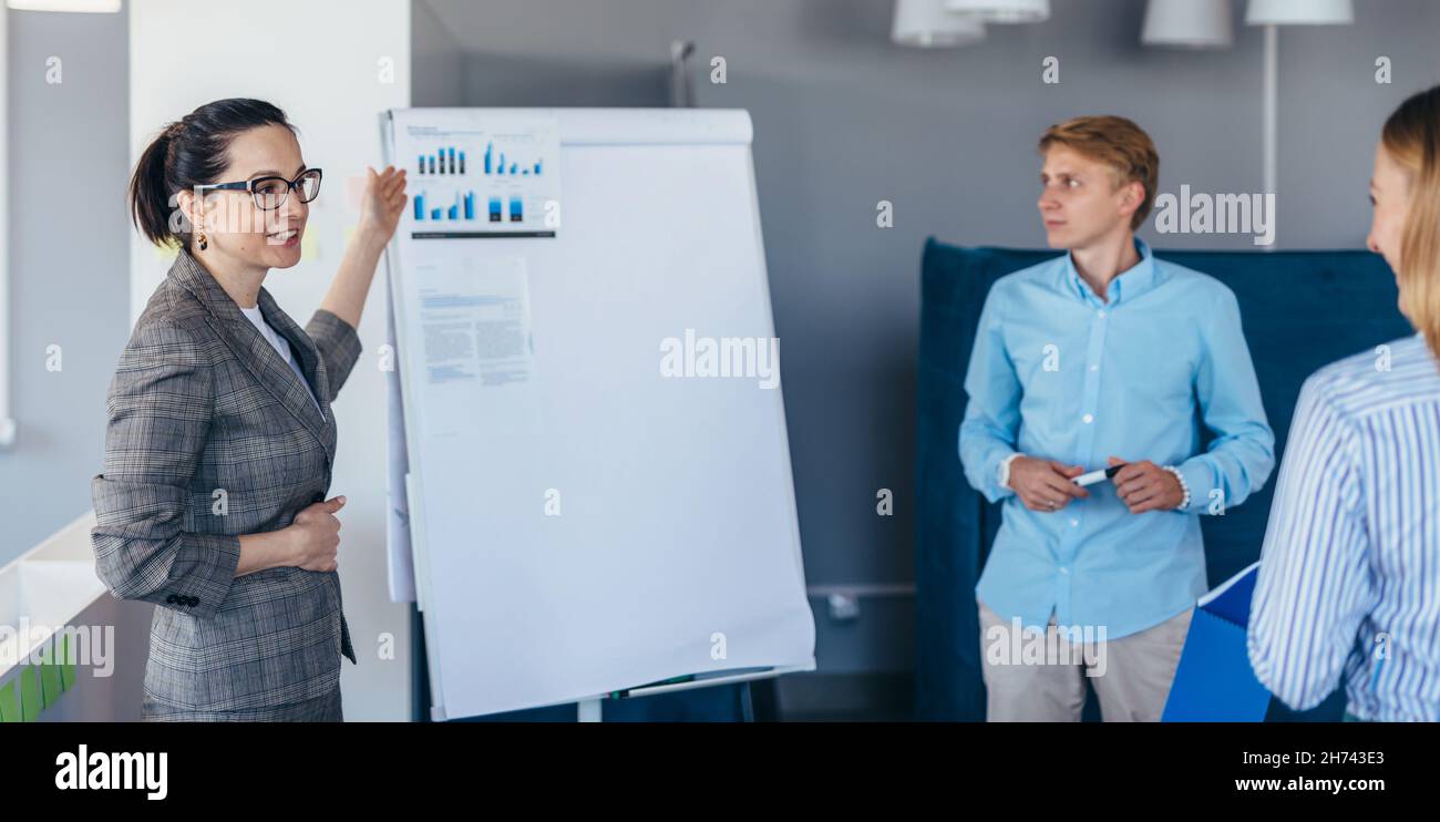 Office worker giving presentation to her colleagues Stock Photo - Alamy