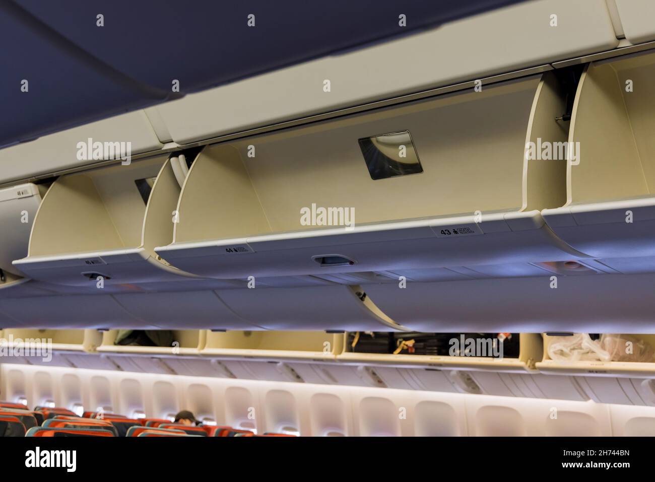 Carry on luggage bags passenger airplane shelves closet, doors opened ...