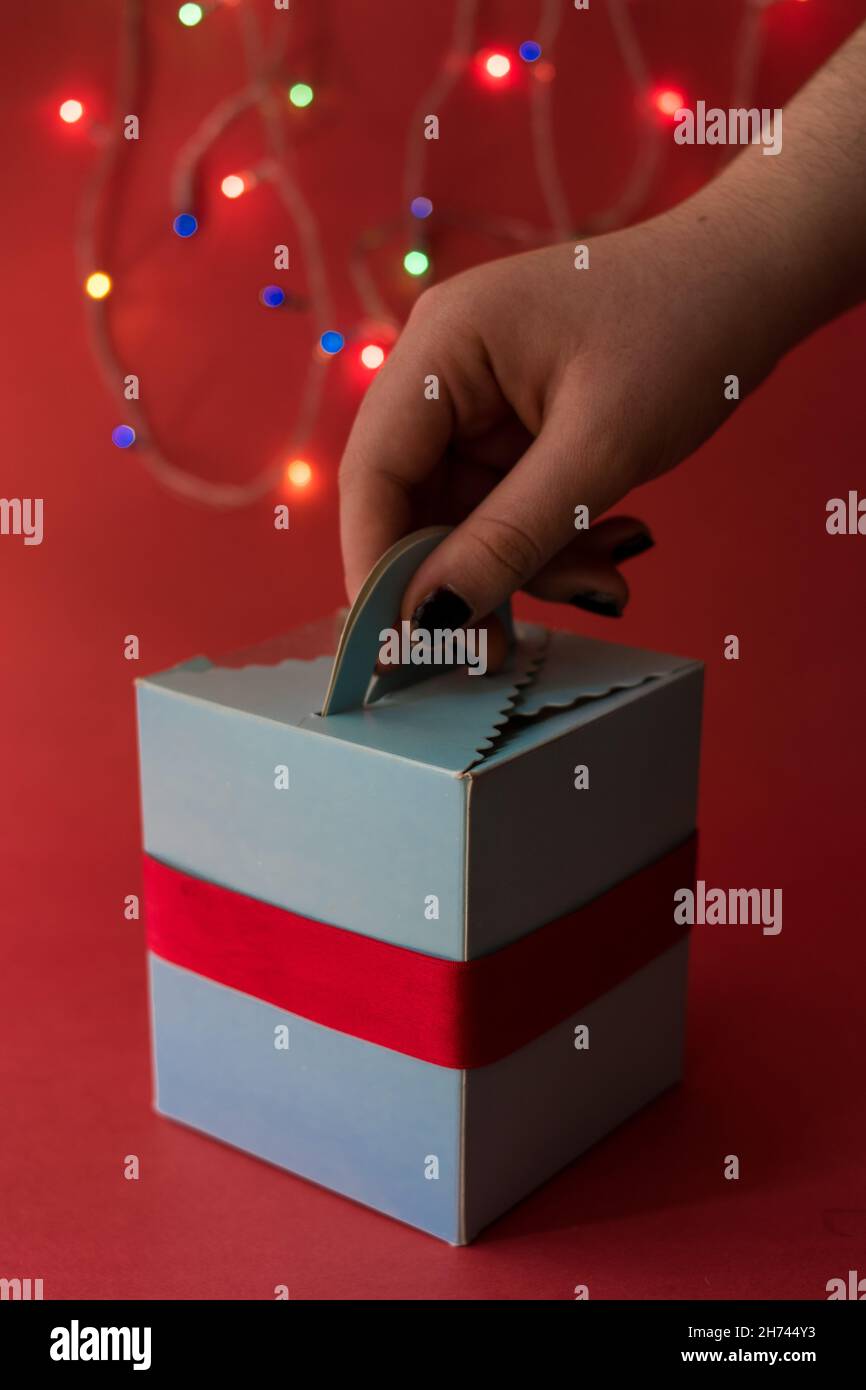 White gift box with a red horizontal bow holder by a female hand Stock ...