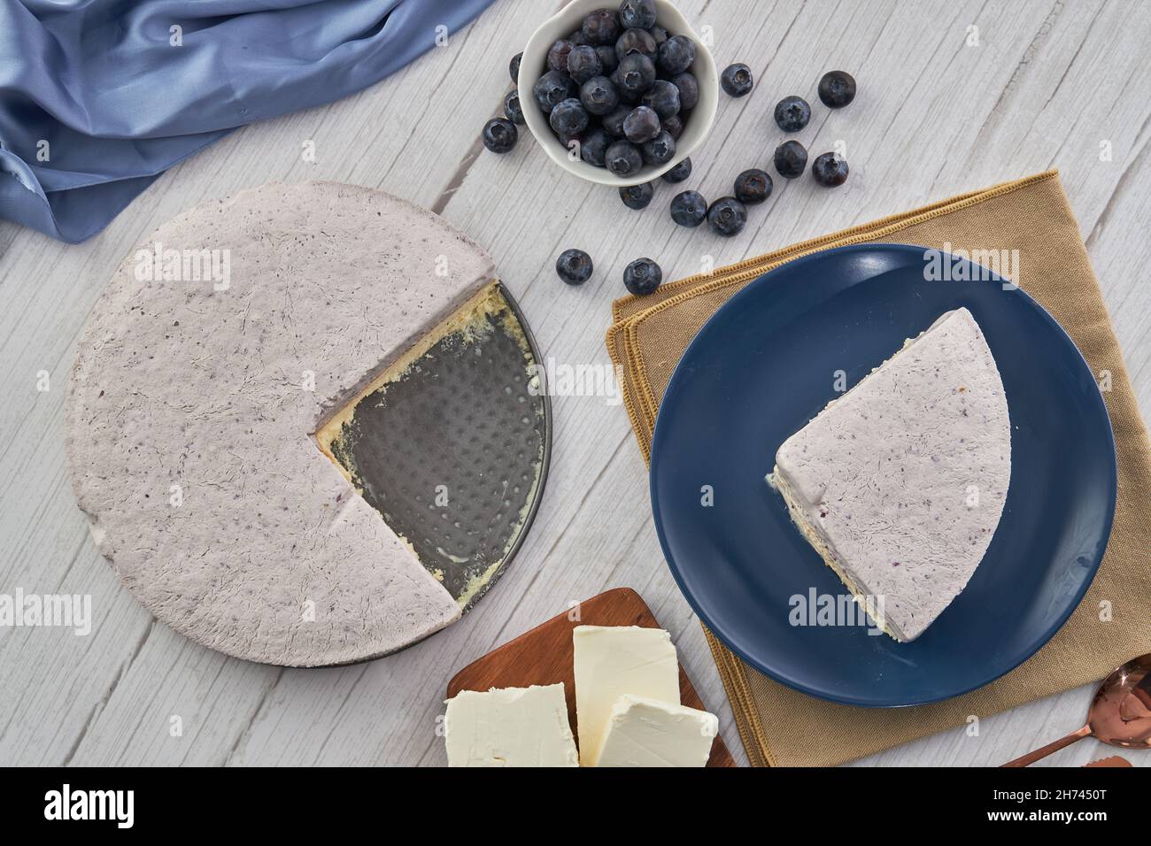 Top view of a sliced blueberry cream cake, berries, and other ...