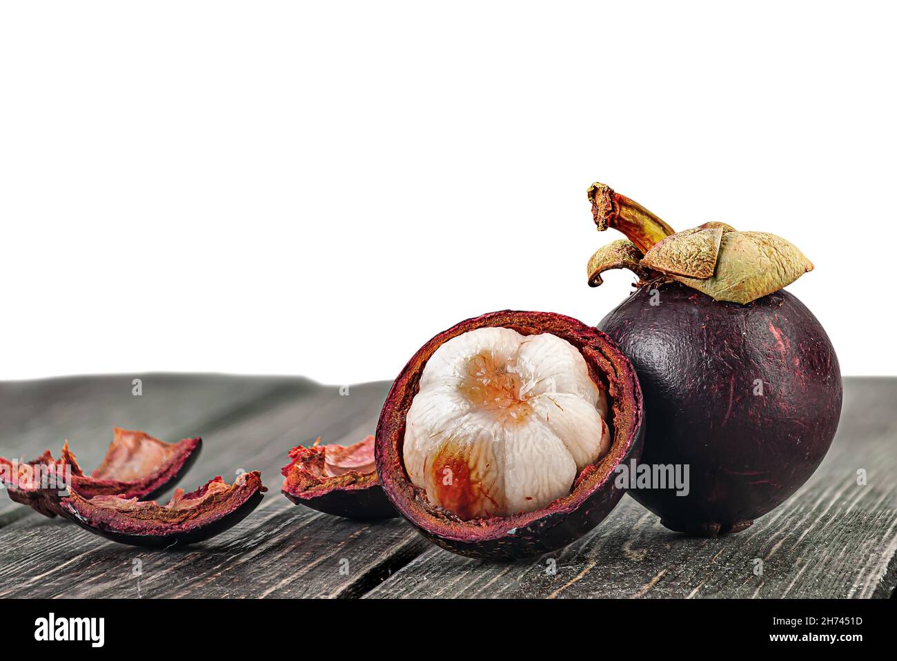 Whole and opened mangosteen with shells on table isolated on white ...