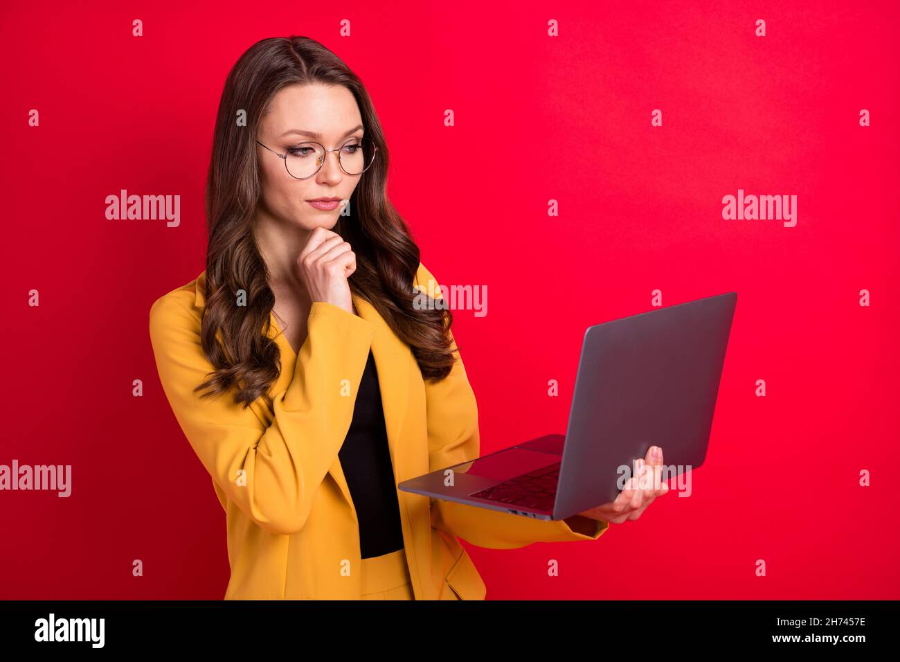 Portrait of gorgeous minded clever lady using laptop reading money ...